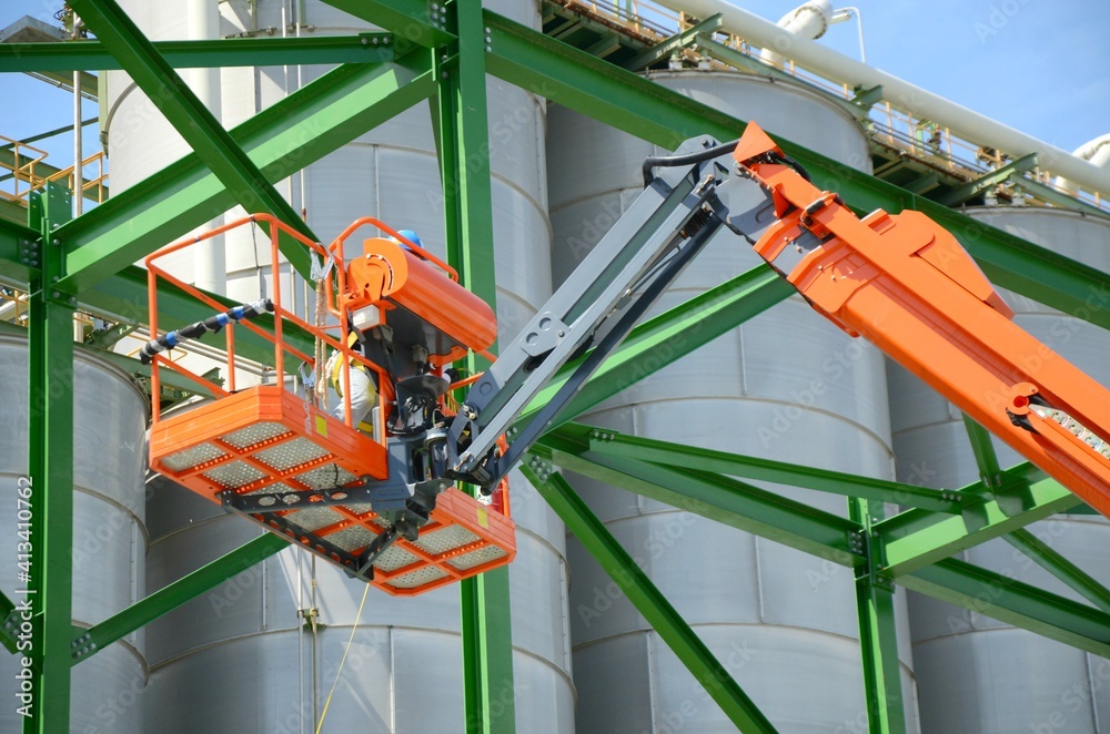 Worker are driving the Orange articulate boom lift or telescopic boom ...