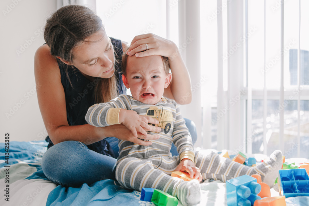 Foto de Mother hugging pacifying sad upset crying toddler boy. Family ...