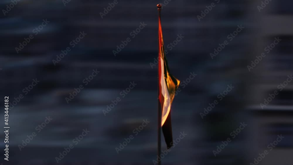 Cinematic flyover of the beautiful waving UAE flag in the dusk sky ...