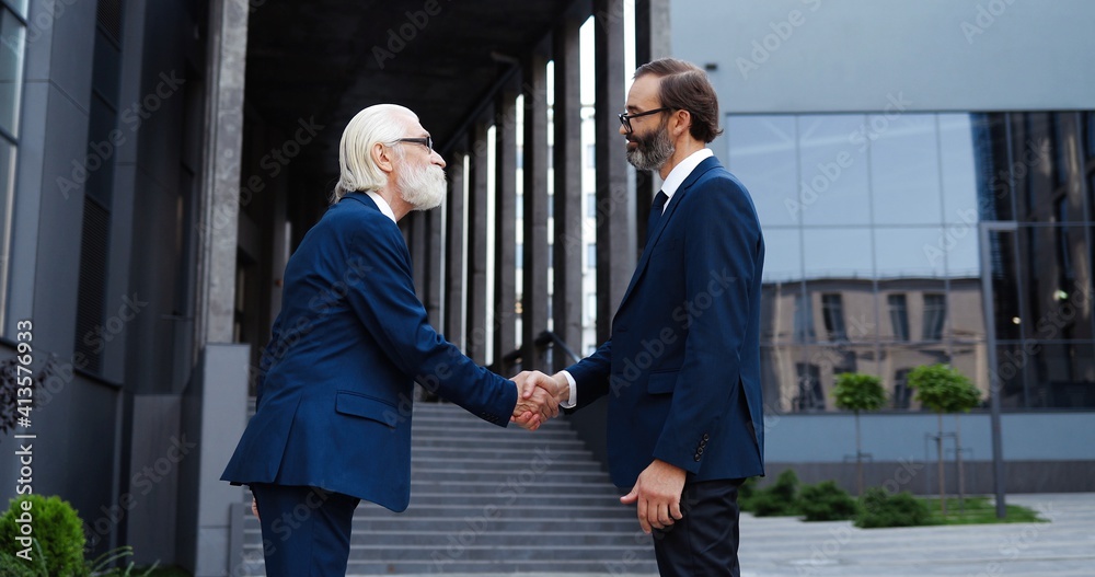 Caucasian senior businessmen in suits and ties meeting outdoor at ...