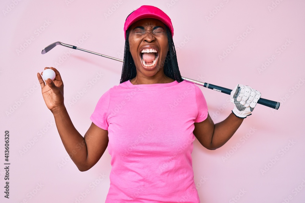 African american golfer woman with braids holding golf ball angry and ...