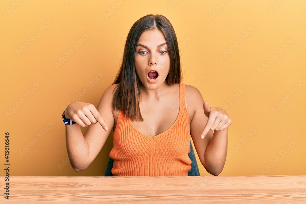 Young caucasian woman wearing casual clothes sitting on the table ...