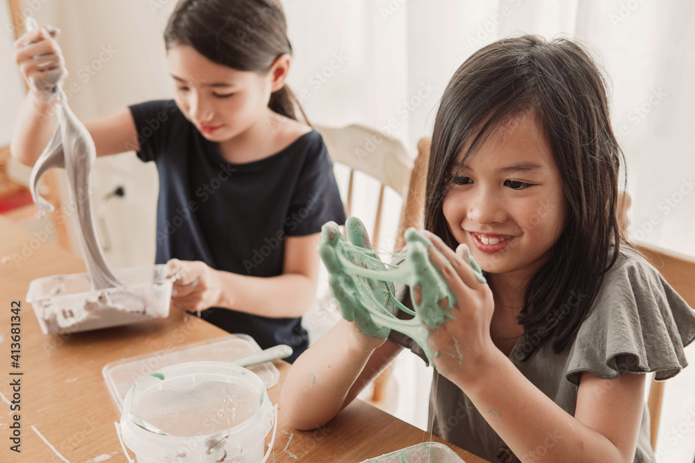 Happy mixed Asian girl friends making homemade slime toy, sensory art ...