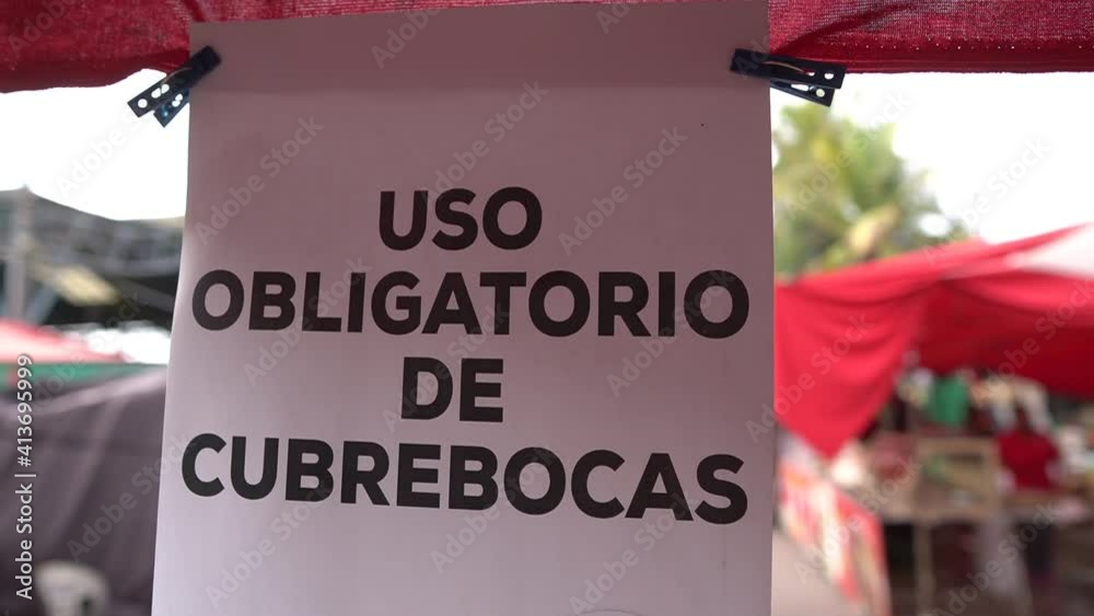 Mandatory use of mask sign written in Spanish. Coronavirus prevention ...