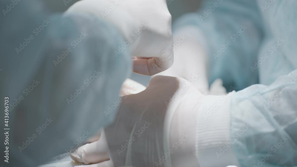 Bloody organ operation. Action. Close-up of two surgeons operating on ...