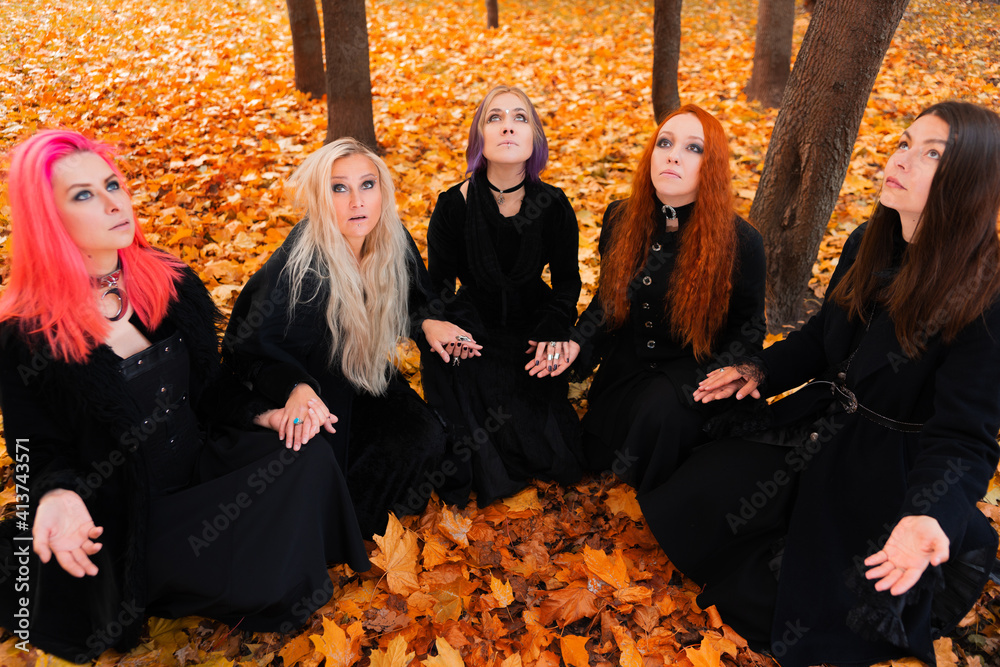Coven of witches, a group of friends as witches on Halloween perform a ...