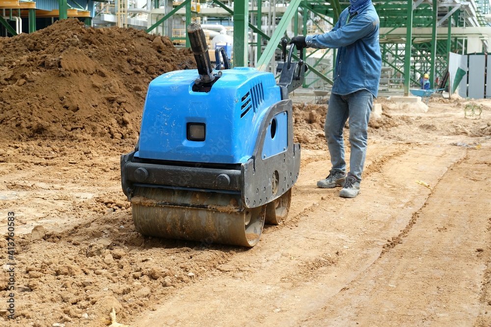 Worker are controlling mini vibratory road roller compactor machine or ...