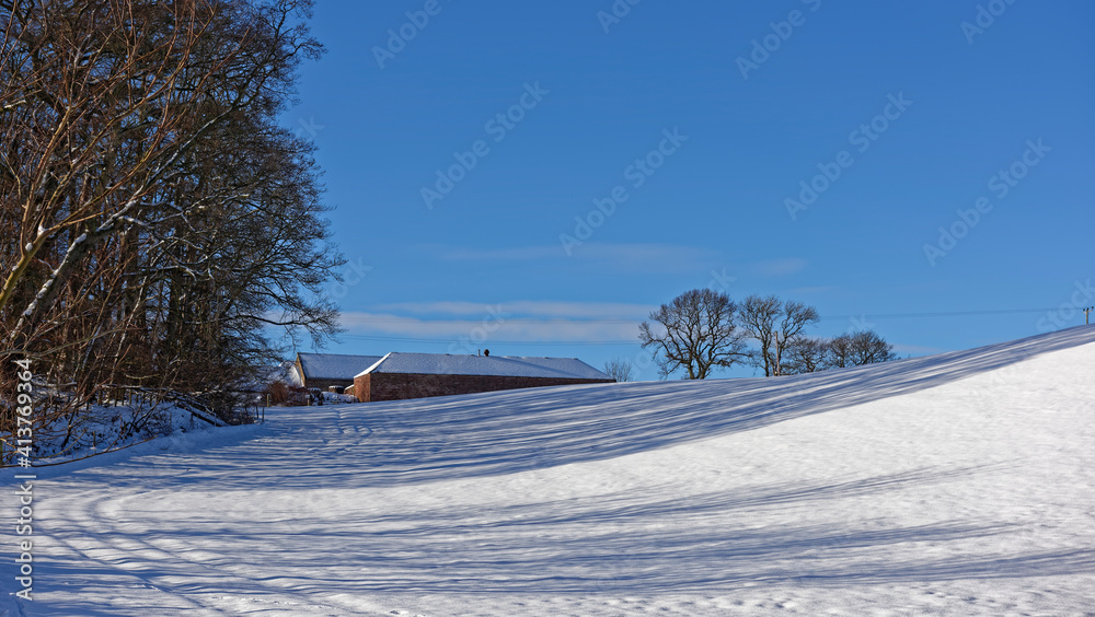 Foto de A Farm and its snow covered Stone outbuildings above a sloping ...