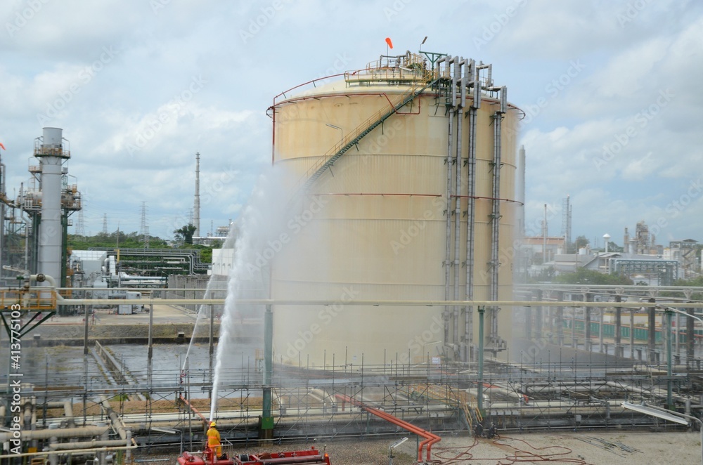 Fireman use fire hose water spray from fire truck to the Large chemical ...