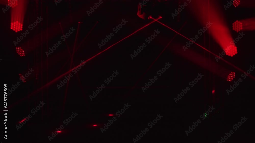 Bright red laser lights and spotlights dynamically rotate and move over ...