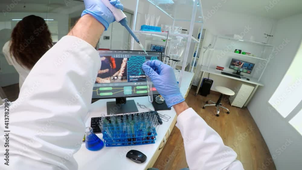 POV of scientist using micropipette in lab to extract blue liquide from ...
