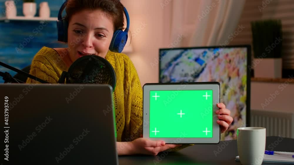 Blogger talking into microphone holding notepad with green screen ...