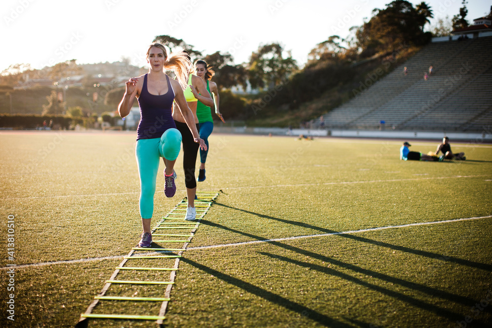 Female athletes training with agility ladder on sports field Stock ...