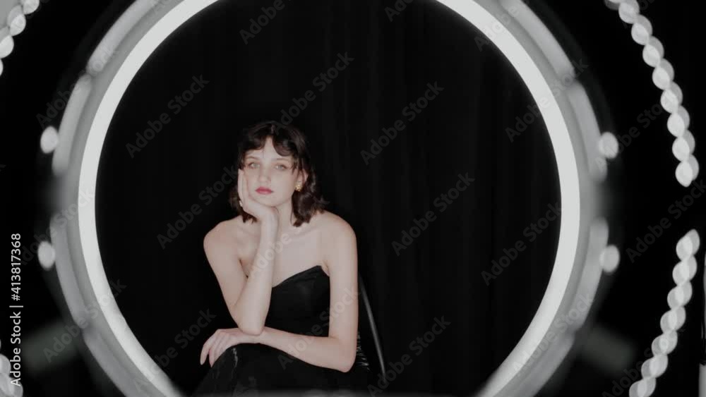 Elegant girl model posing in studio. It is illuminated by a special ...