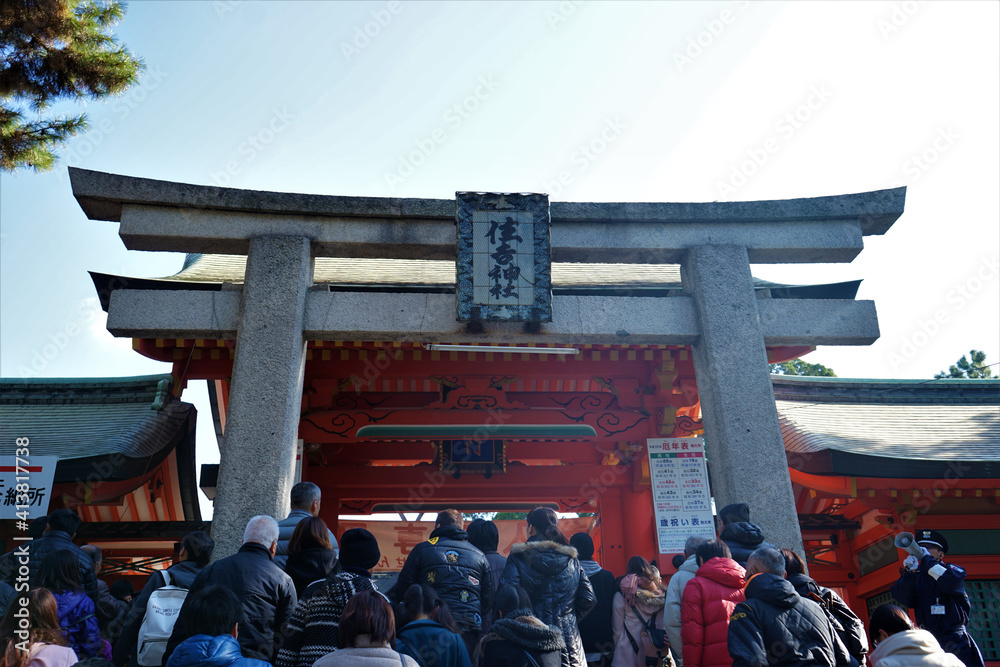 Crowd of people standing in a queue at Torii gate of Sumiyoshi jinja ...