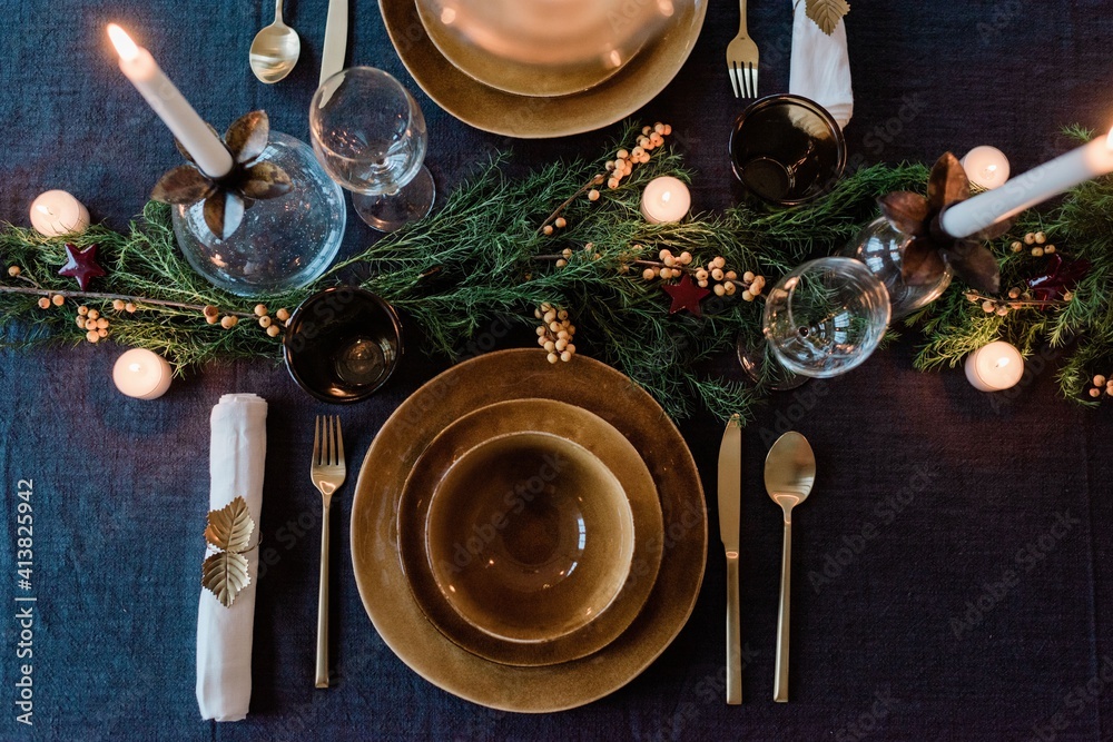 sky view of a modern dinner table setting with candles and greenery ...