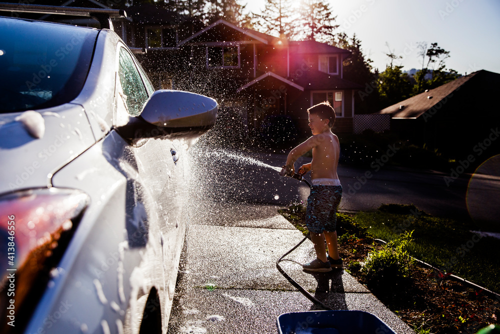 side view of boy washing car with hose Stock Photo | Adobe Stock