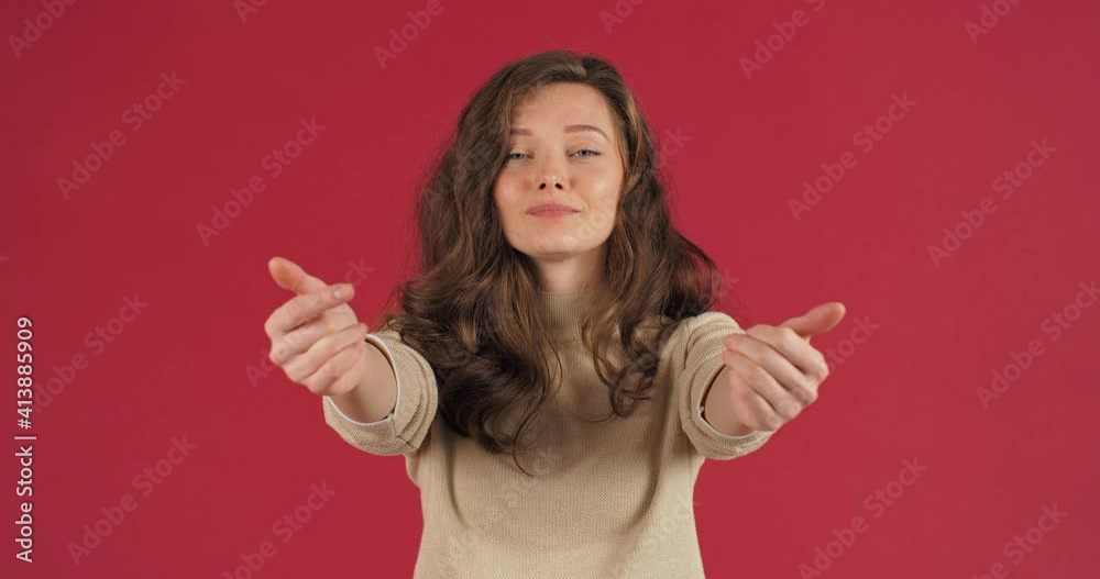 Beautiful caucasian young woman showing inviting gesture with hands. Come here. Girl student ...
