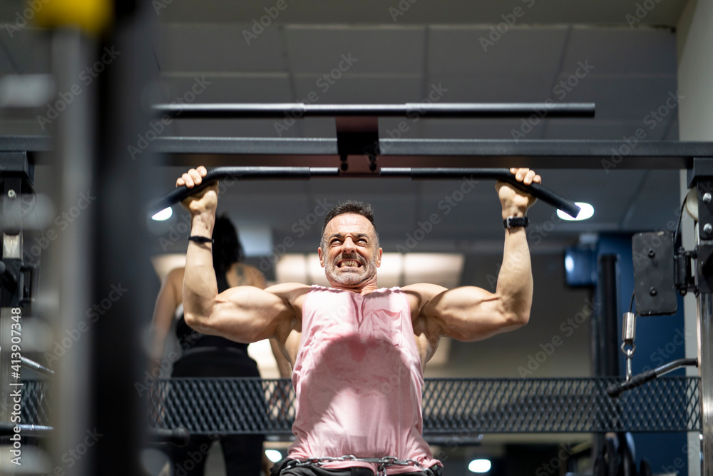 Strong man training his back in gym with dumbbells. Stock Photo | Adobe ...