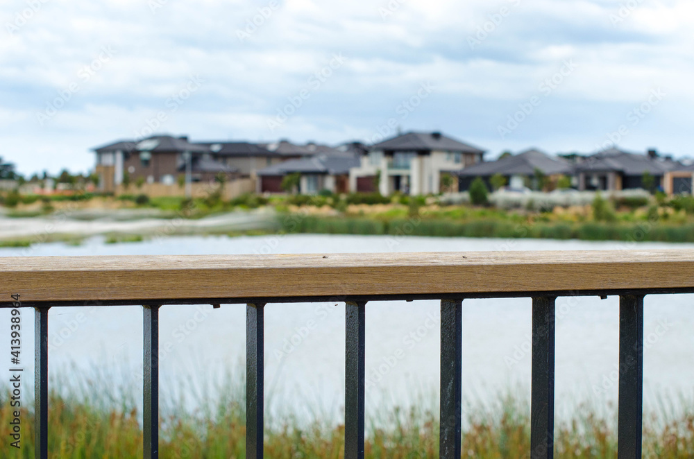 Fence rail of a viewing platform with a blurry view of a lake and ...