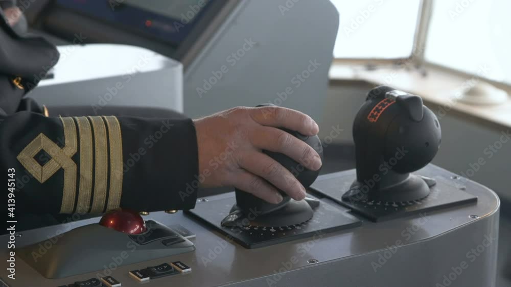 Captain steers the ship by azimuth controller. Captain's hand is on the ...