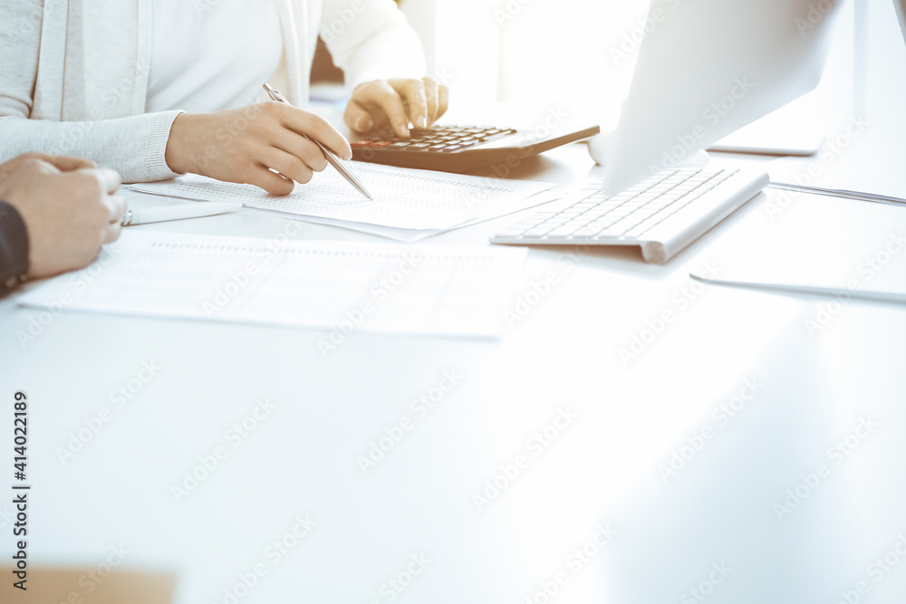 Accountant checking financial statement or counting by calculator ...