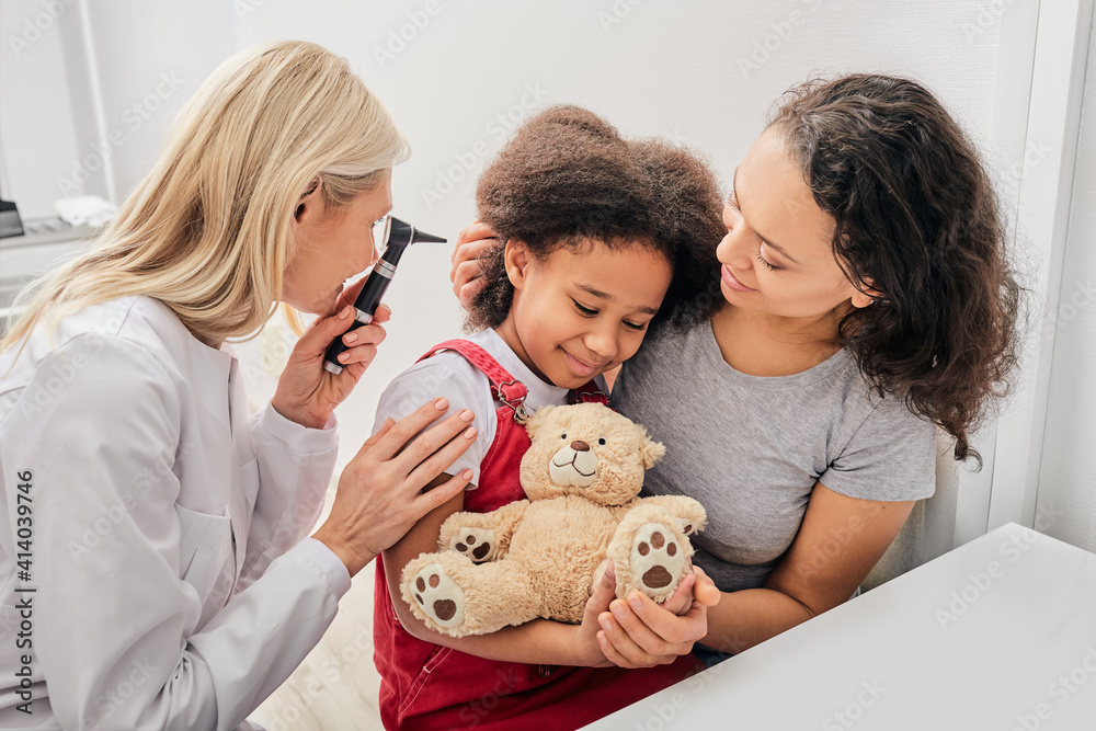 Hearing exam. Child with her mother during a hearing test, audiologist ...
