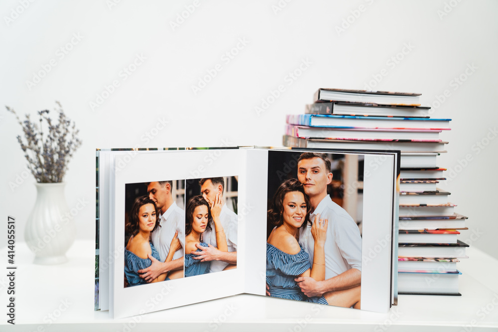 a stack of books. open photobook from photo shoots of a beautiful happy ...