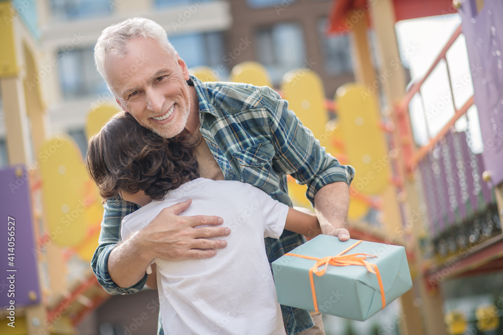 Happy father giving a gift to his son and both looking excited Stock ...