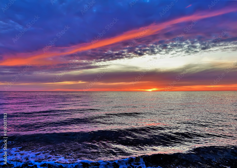 Bright sunset over the sea. The sun has almost disappeared over the ...