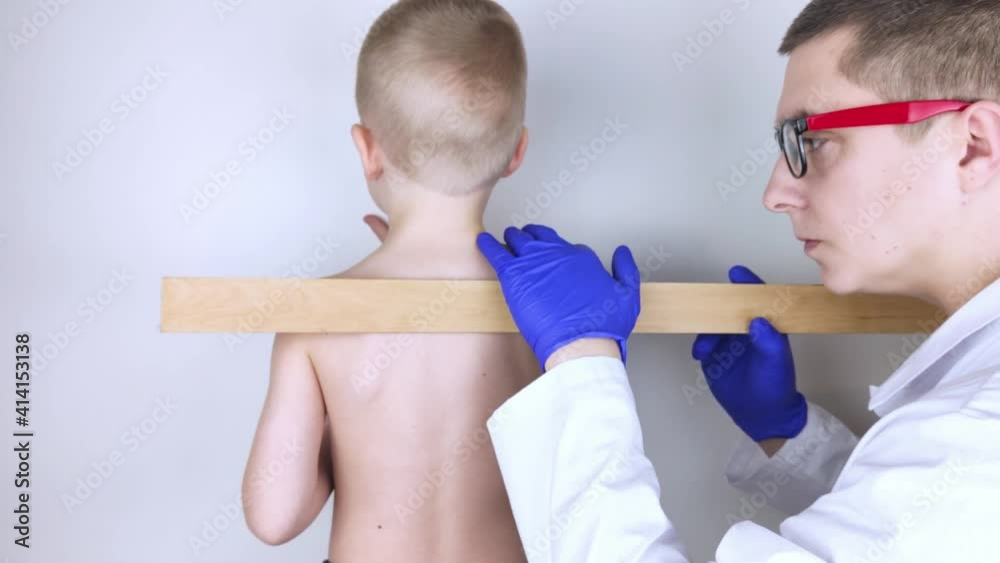 A little boy at the doctor's appointment with back pain. Treatment of ...