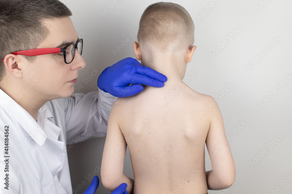 A little boy at the doctor's appointment with back pain. Treatment of ...