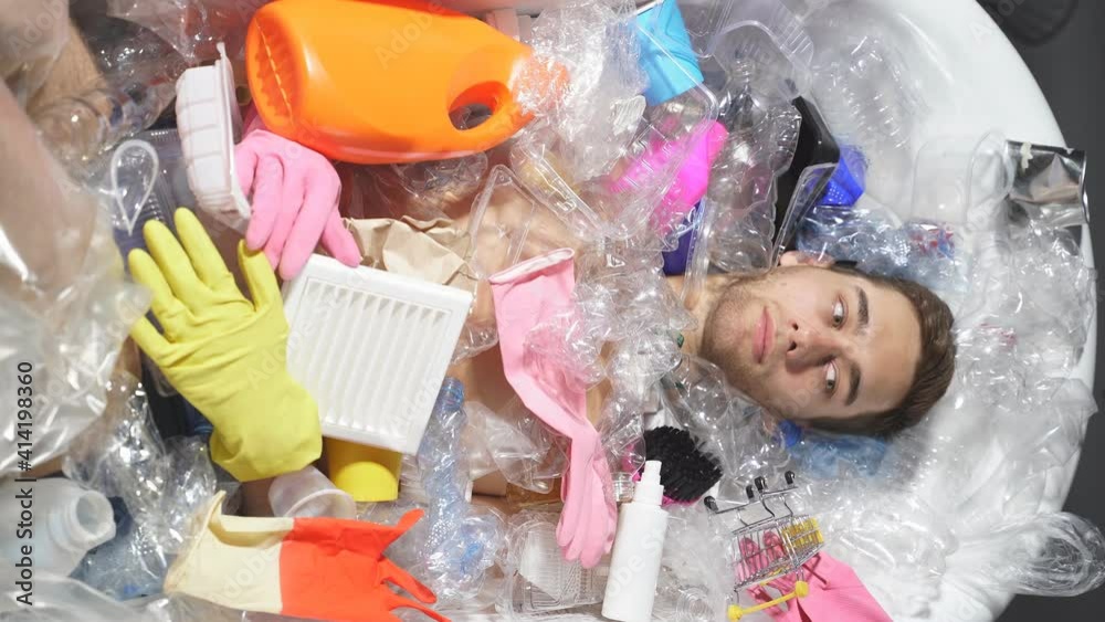 Man drowning under plastic recipients pile, garbage, used packs filling ...
