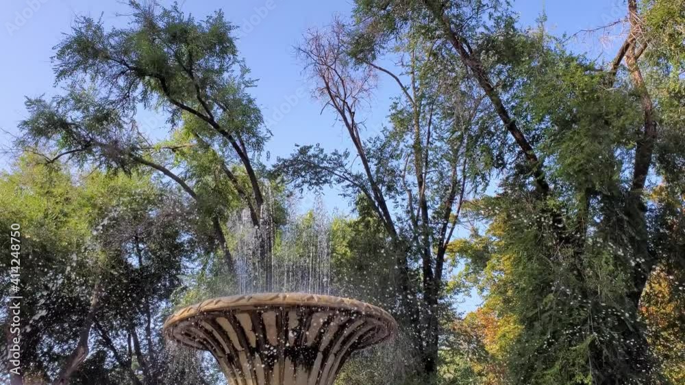 Tilt view through shiny drops and water jets of ornate sculptural ...