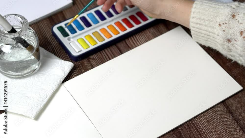 Art set up with paints, brushes, water and paper viewed from above at ...