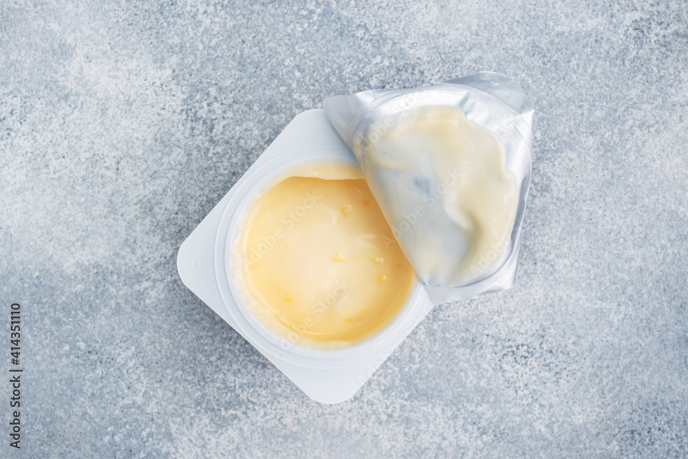 Milk fruit yogurt in an open package. Gray concrete background, Stock ...