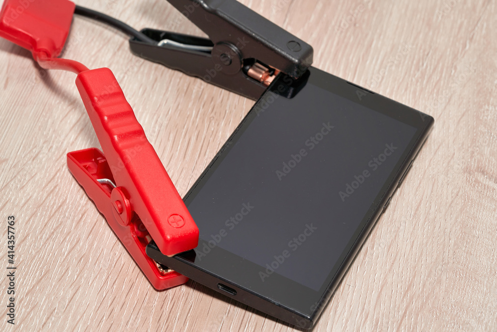 crocodile clips are connected to the body of the smartphone Stock Photo ...