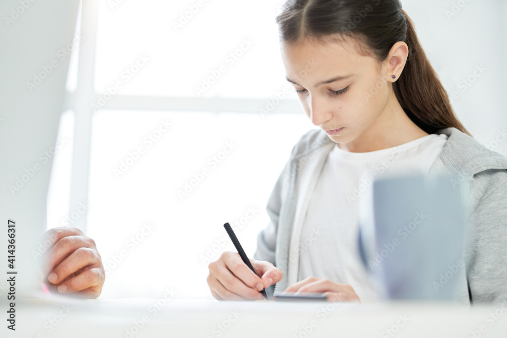Diligent student. Focused teenage latin girl drawing something while ...