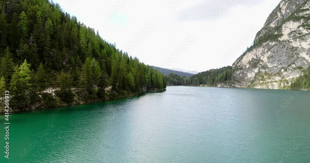 Low Flying Drone view of lake braies in the Alps. Clear and calm water ...