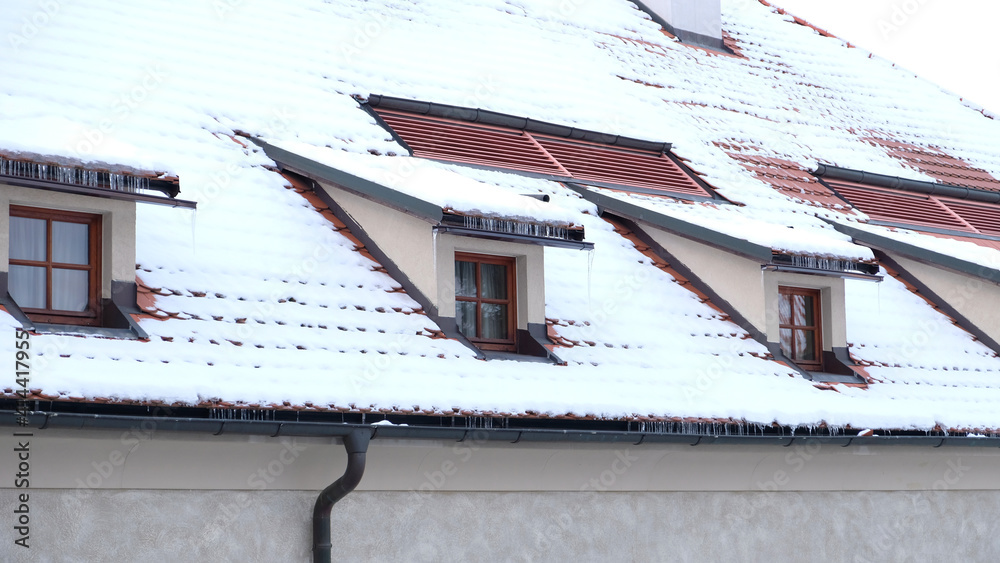 Exterior of apartments with gable roofs and dormers covered with snow ...