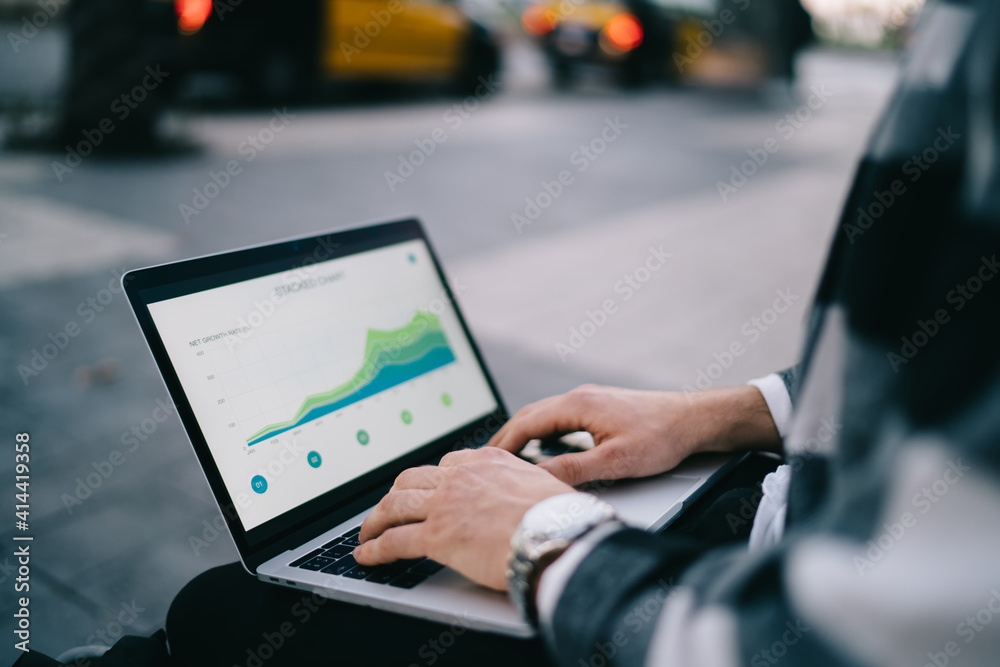 Cropped image of man's hand typing on laptop computer searching ...
