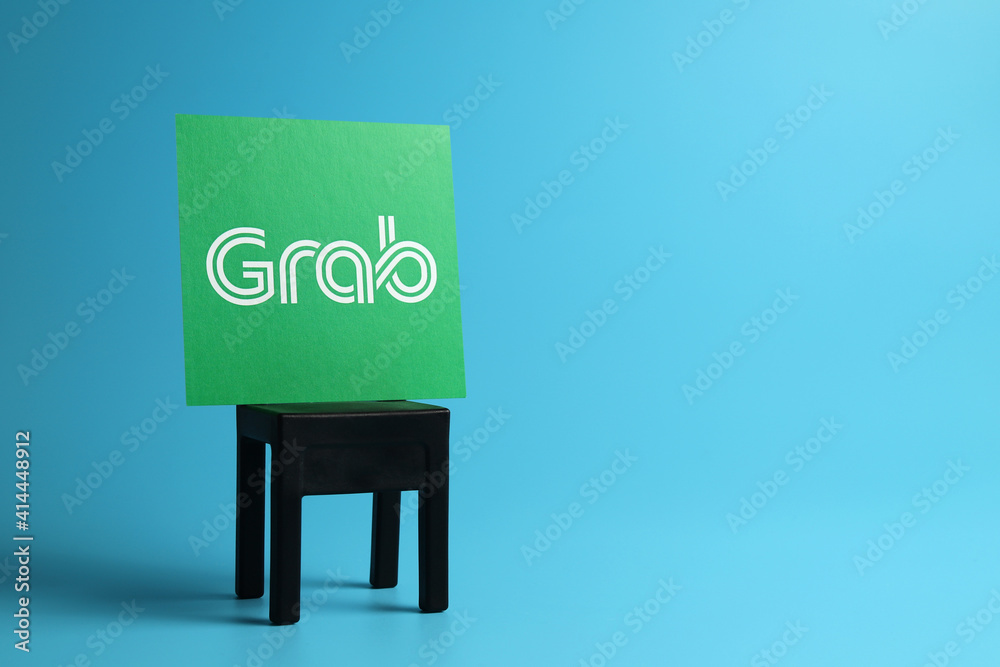 Grab logo on a black chair against blue background. Grab, is a ...