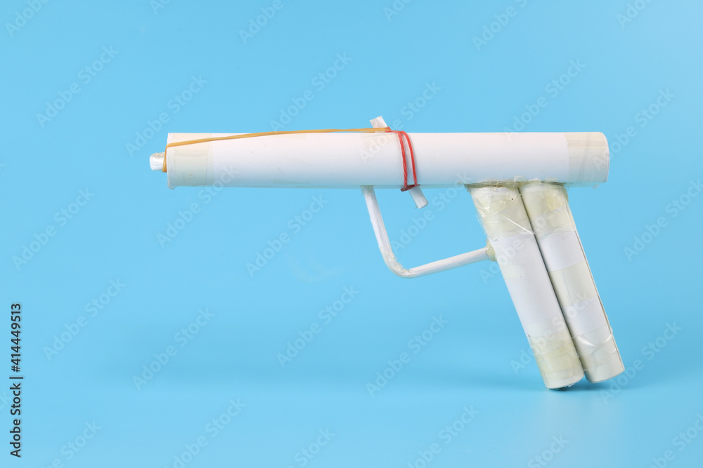 Paper gun that shoots rubber bands isolated on light blue background ...