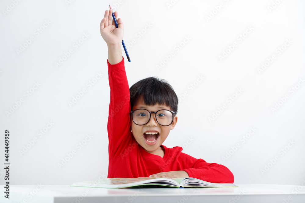 Smart little Asian boy raised up his hand in class to answer a question ...