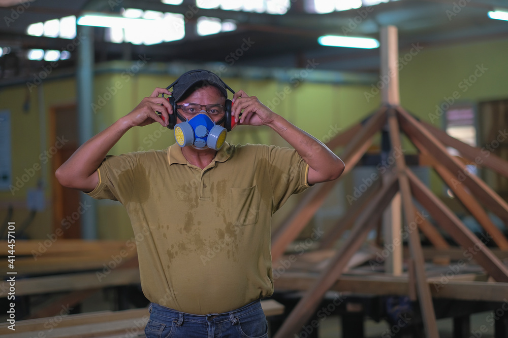Carpenter wearing PPE in installation of roof rafters on a new gazebo ...