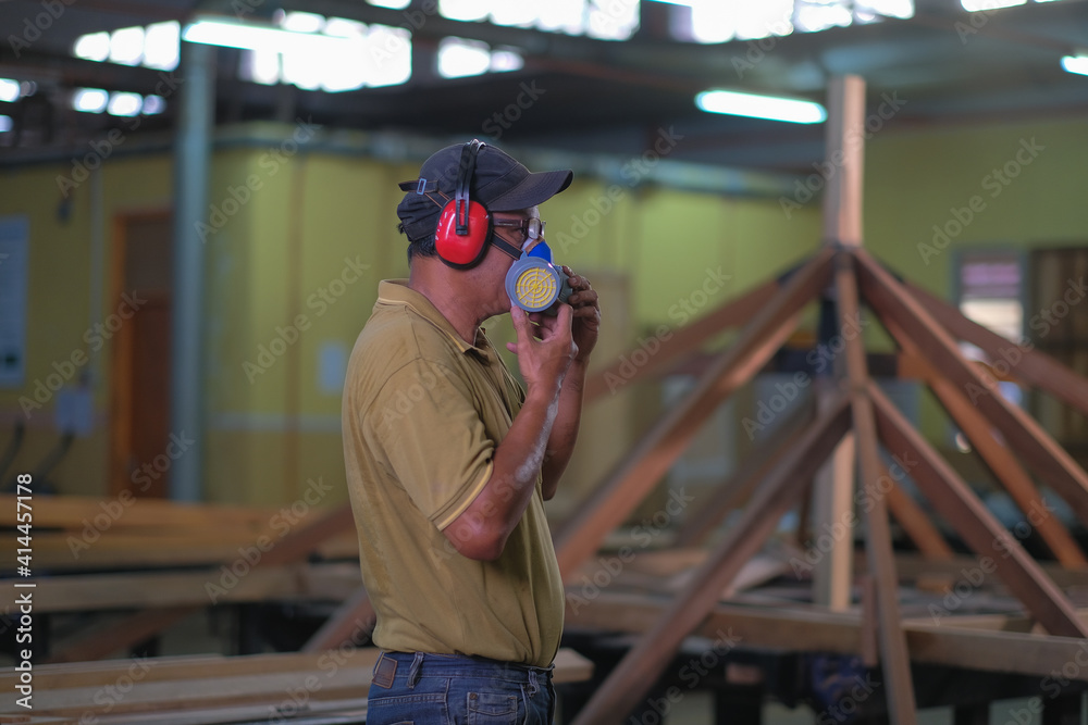 Carpenter wearing PPE in installation of roof rafters on a new gazebo ...