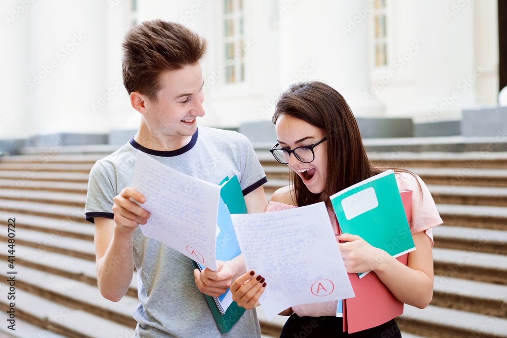Foto de Two excited students with excellent exam results outdoor near ...