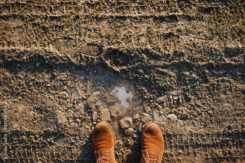 feet in boots are on the ground, top view Stock Photo | Adobe Stock