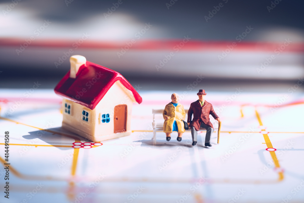 Miniature elderly people sitting with mini house using as job ...