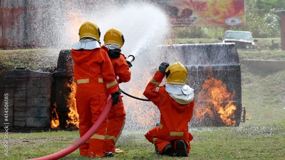 Firefighter fighting with fire flame protection property. Fireman wear ...